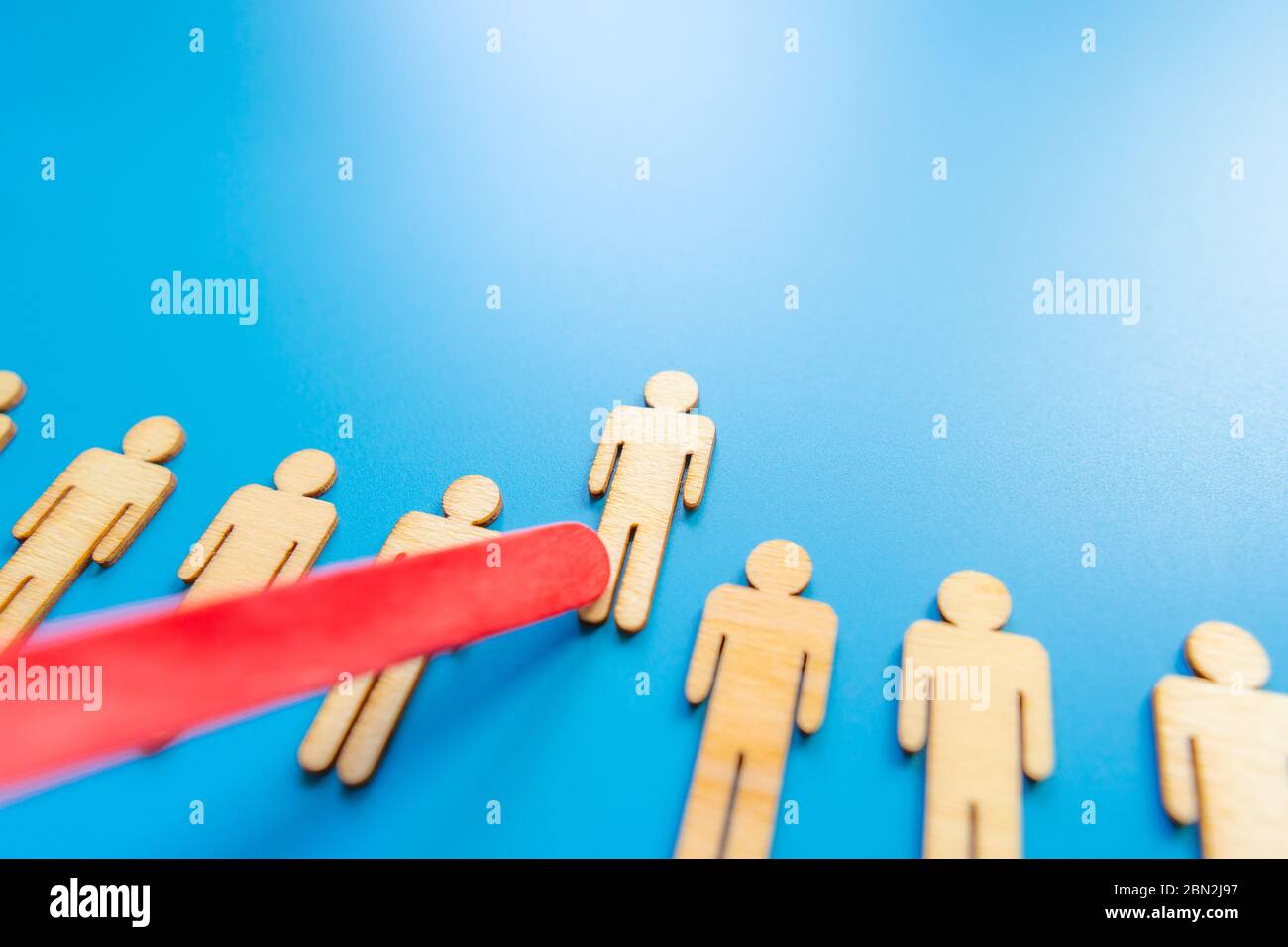 Selected wooden figure on blue background. The concept of finding an ...