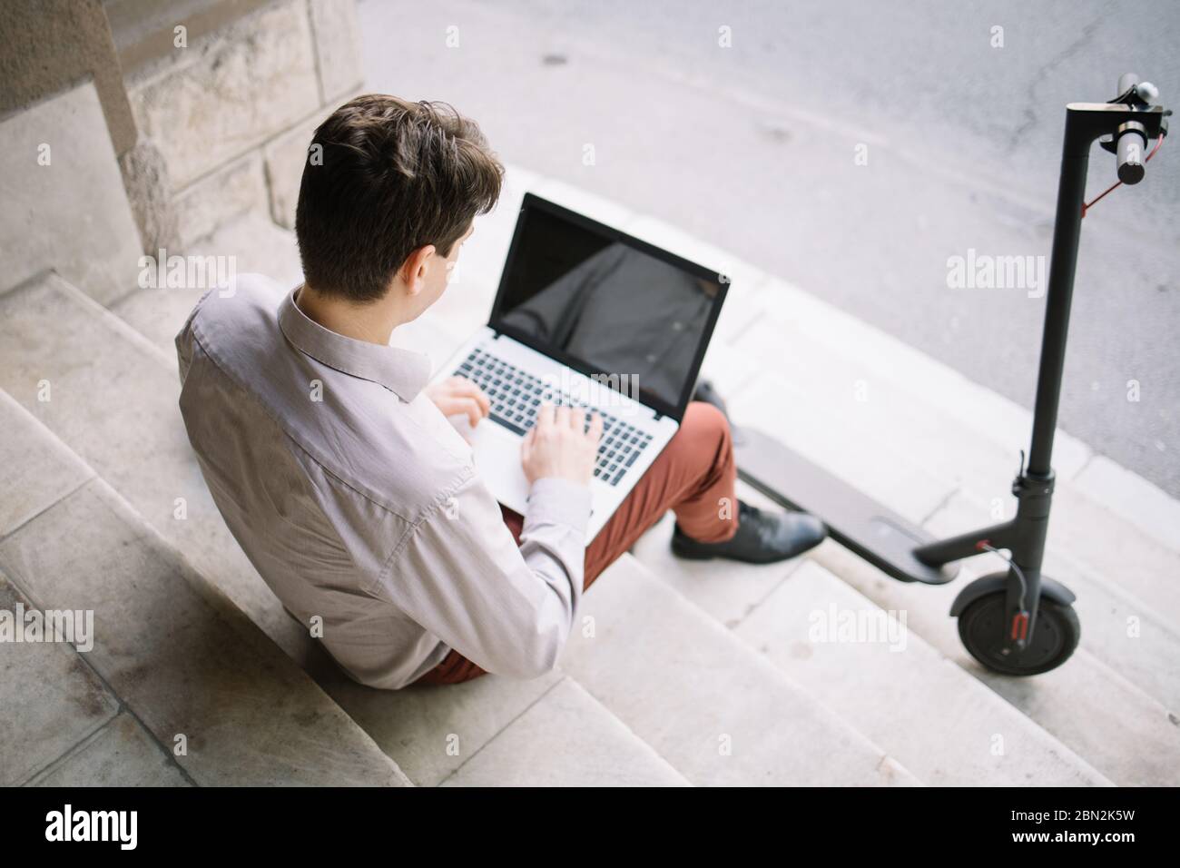 Top view of boy using laptop while sitting on stairs. High angle view ...