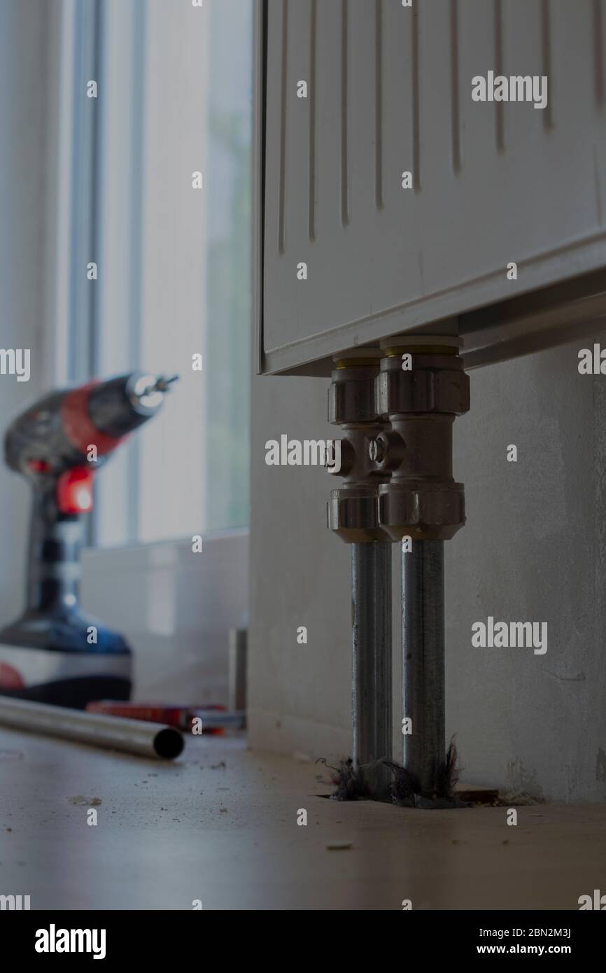 Connection valves under a radiator, on the floor much dust and dirt ...