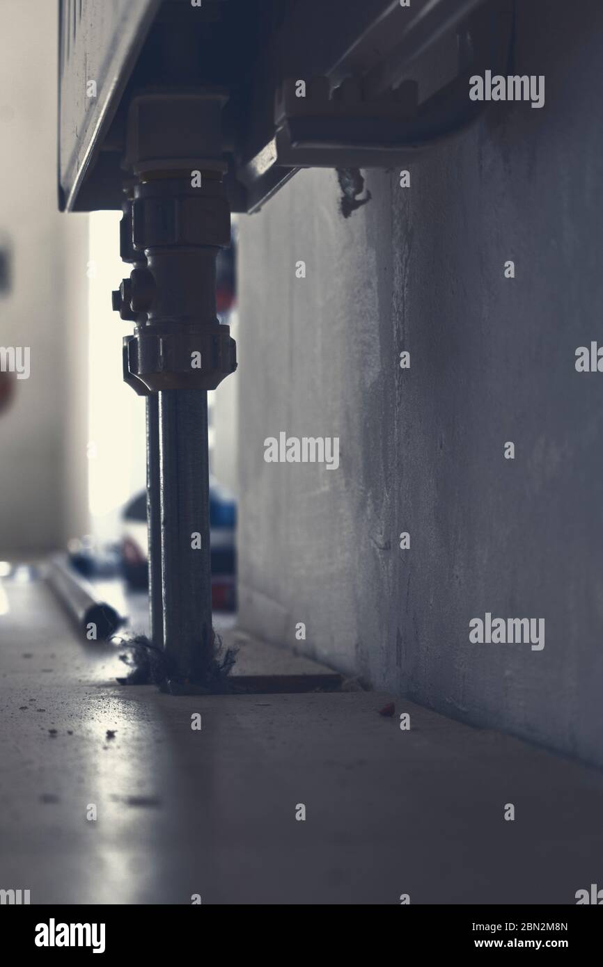 Connection valves under a radiator, on the floor much dust and dirt ...