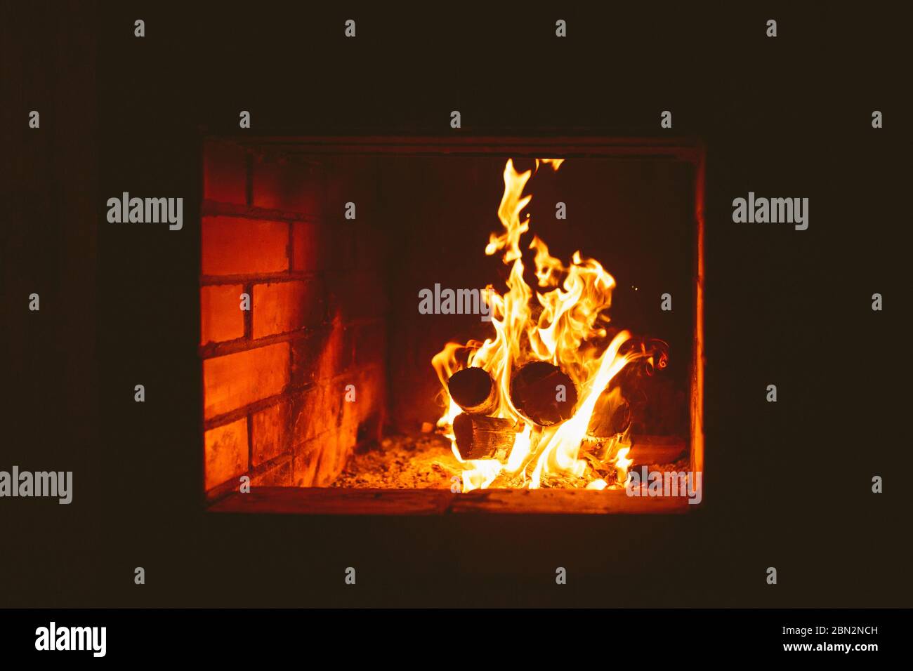 Cozy fire in brick fireplace close-up, burning logs Stock Photo - Alamy