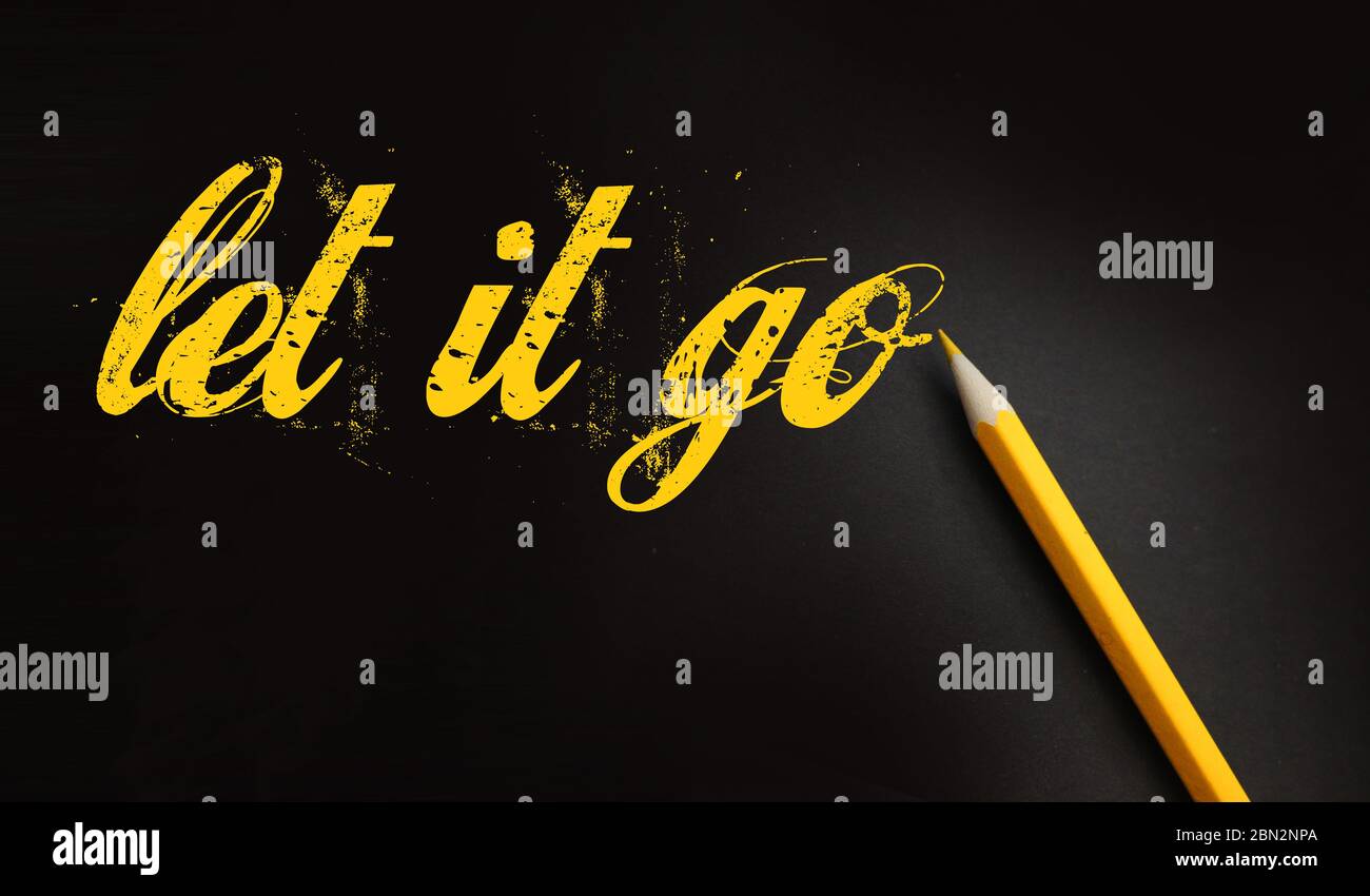 Let it go words written with a yellow pencil on black. Forgiveness ...