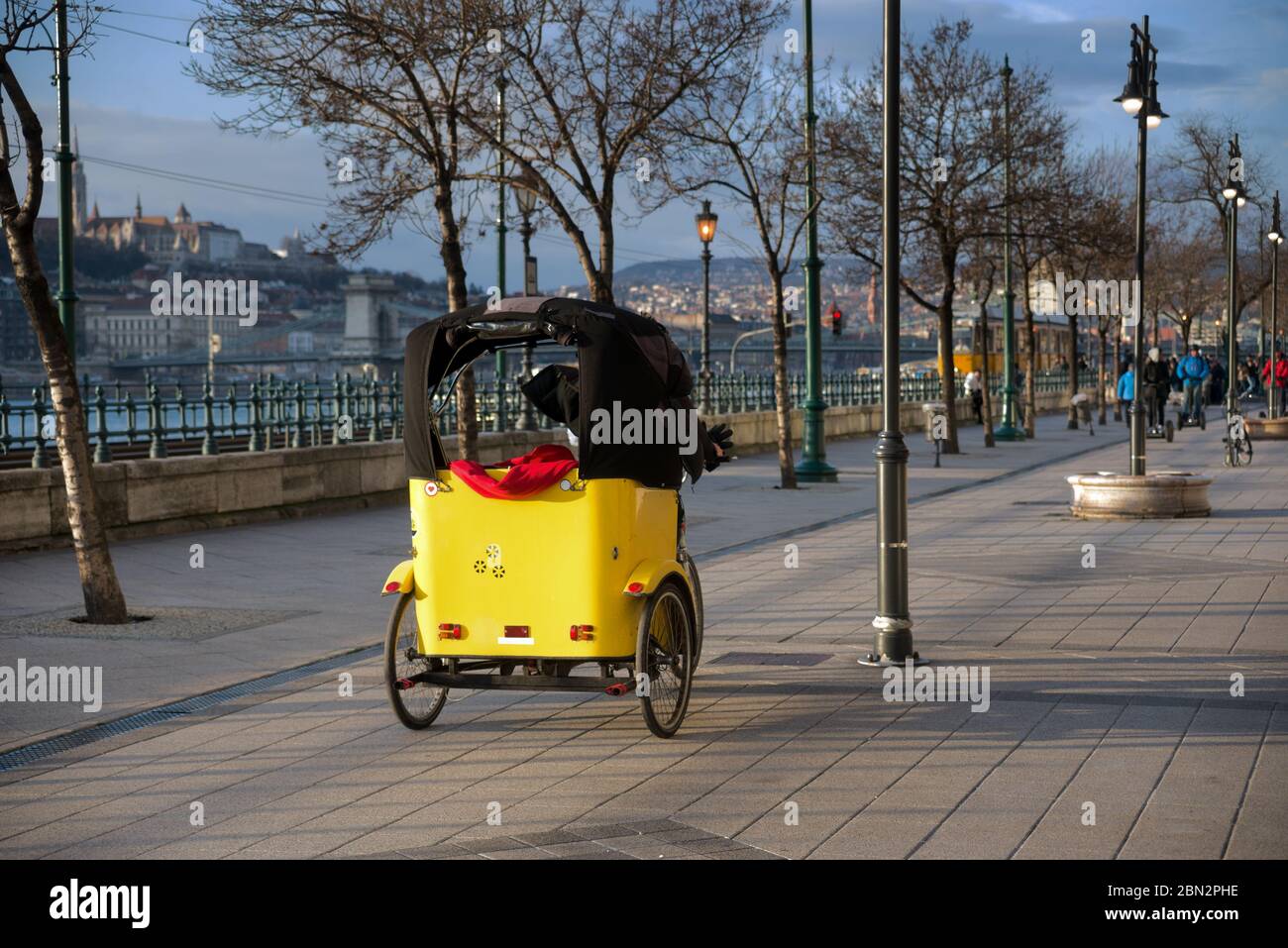 Rickshaw yellow wagon on a riverfront promenade of Budapest, Hungary ...