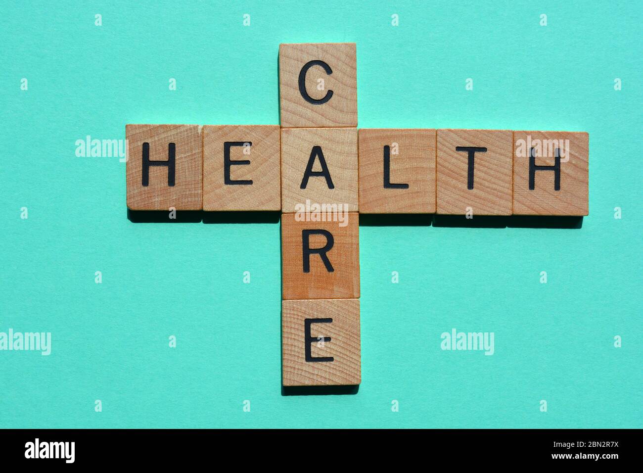 Health, Care, words in wooden alphabet letters isolated on turquoise ...
