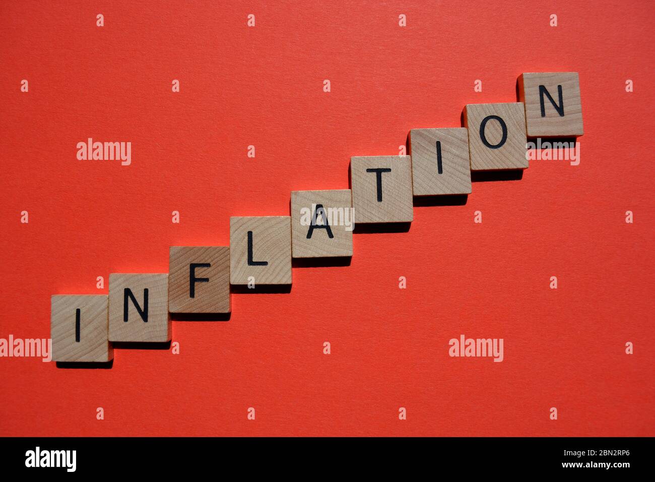 Inflation, word in 3d wood alphabet letters isolated on red background ...