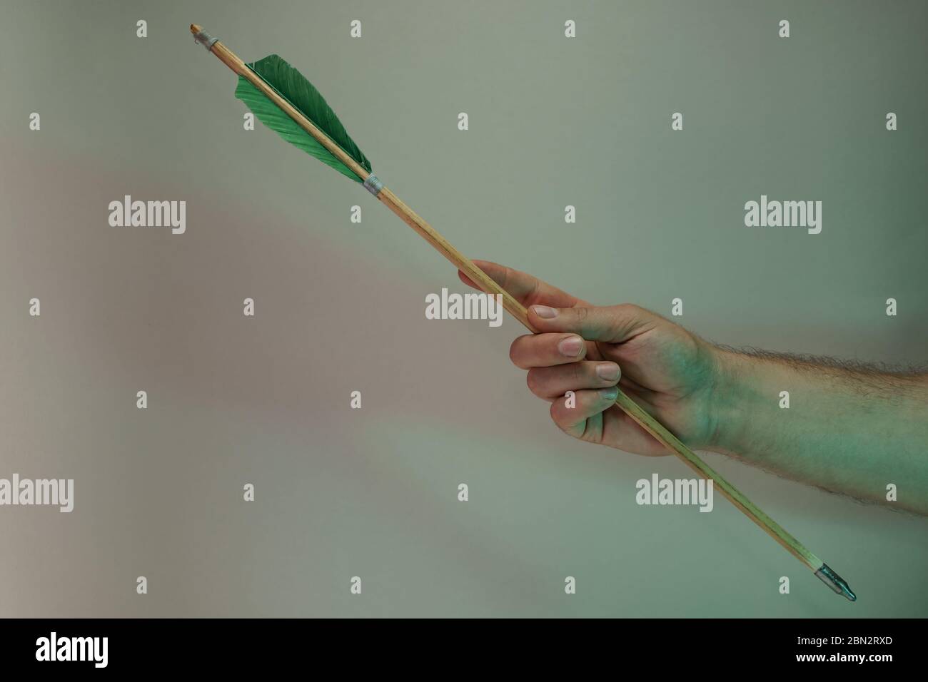 Hand holding old green arrows in the color light. Beautiful old arrow ...