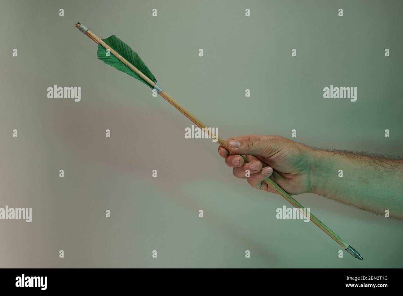 Hand holding old green arrows in the color light. Beautiful old arrow ...