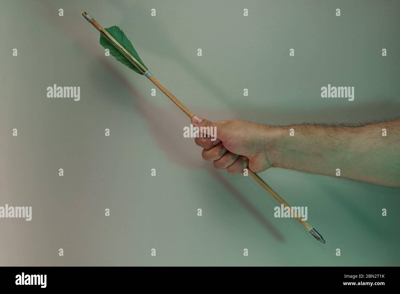 Hand holding old green arrows in the color light. Beautiful old arrow ...