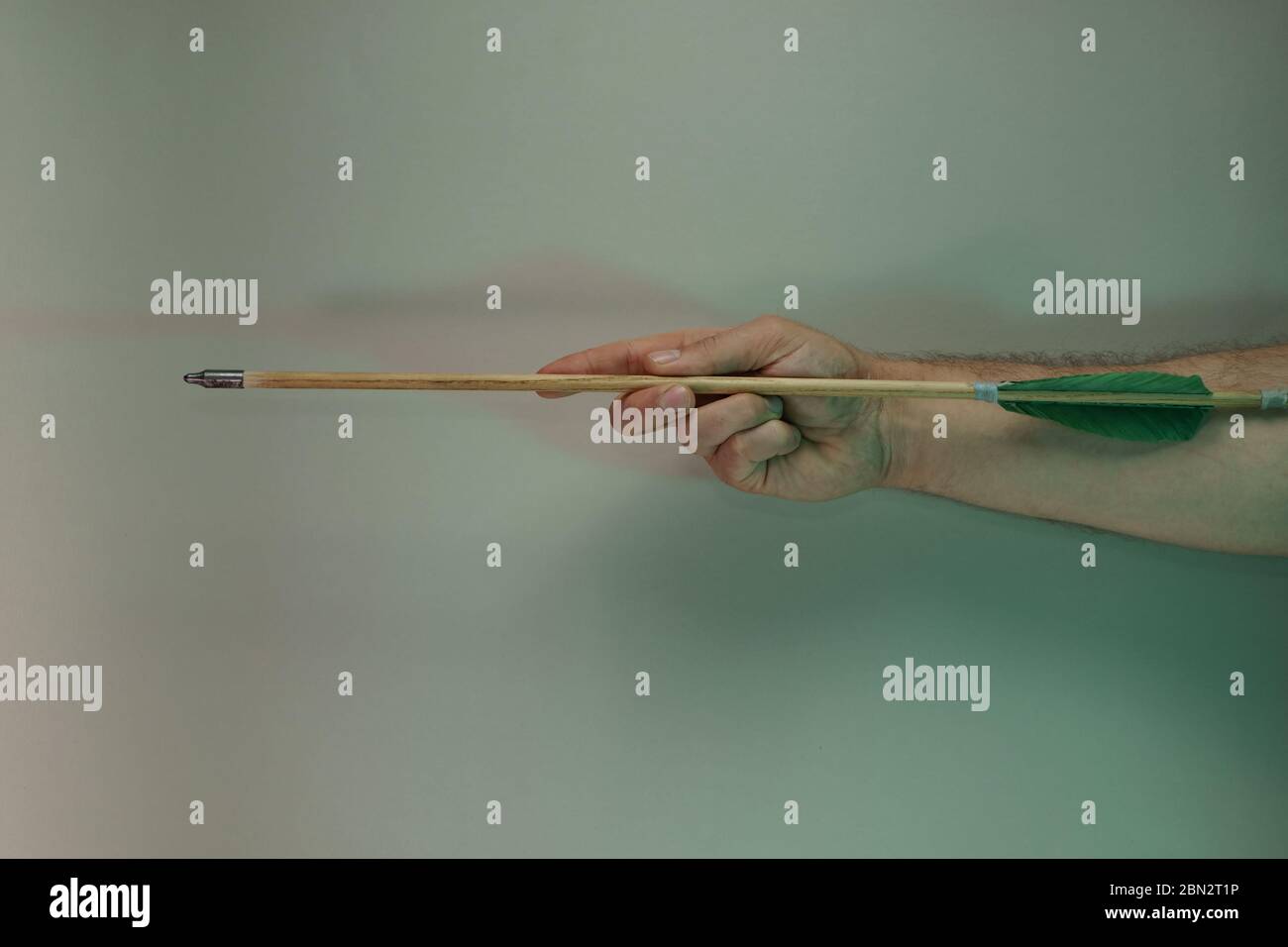 Hand holding old green arrows in the color light. Beautiful old arrow ...