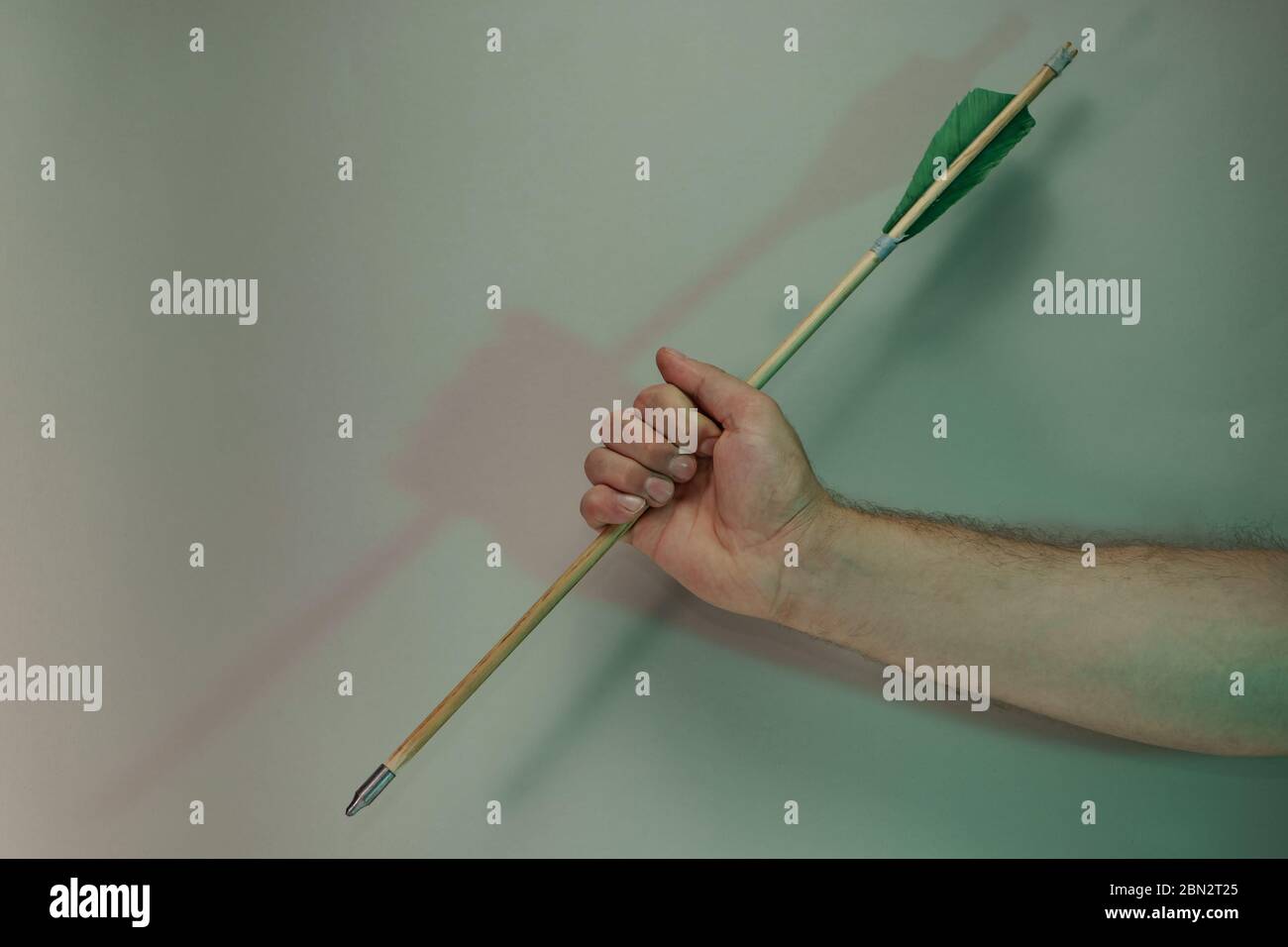 Hand holding old green arrows in the color light. Beautiful old arrow ...