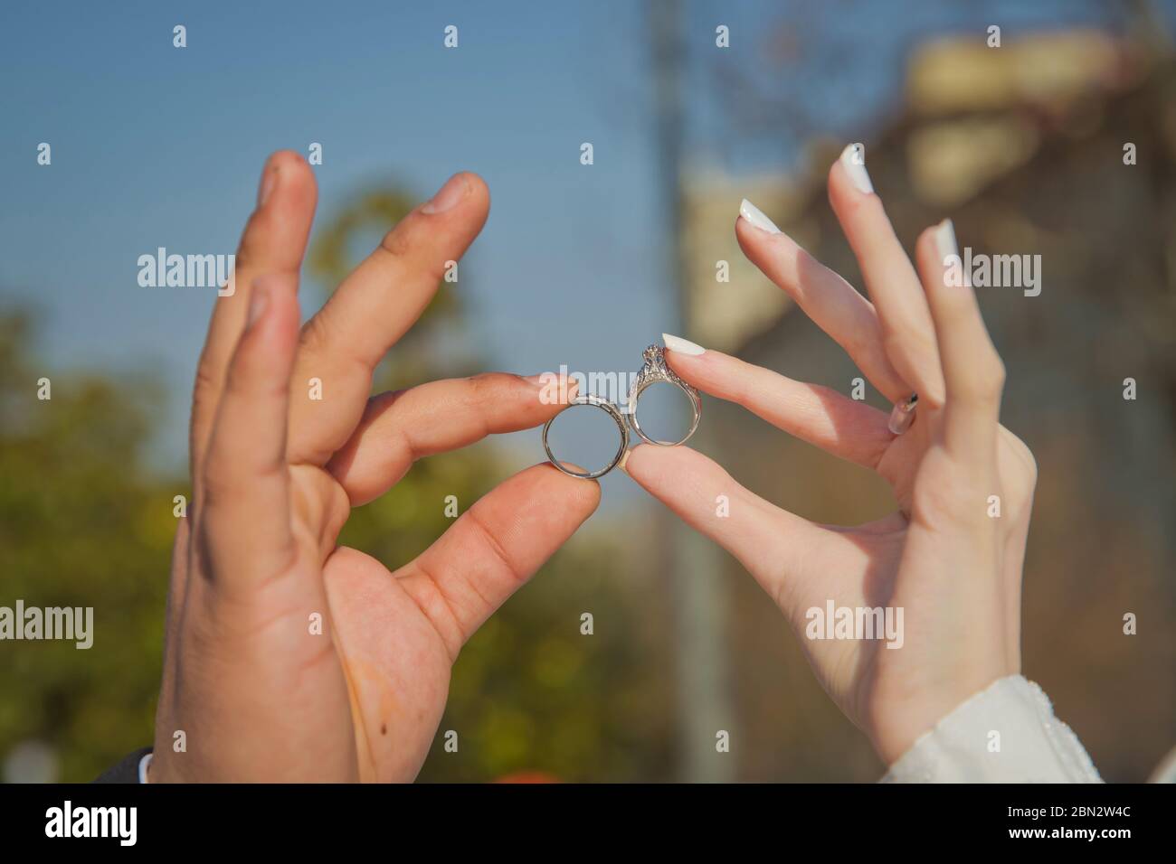 Bride and groom doing the infinity sign combining their wedding rings ...