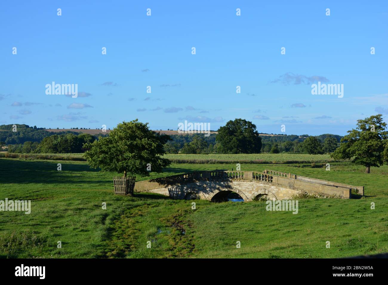 Summer landscape with old stone bridge over Hovingham Beck, North ...