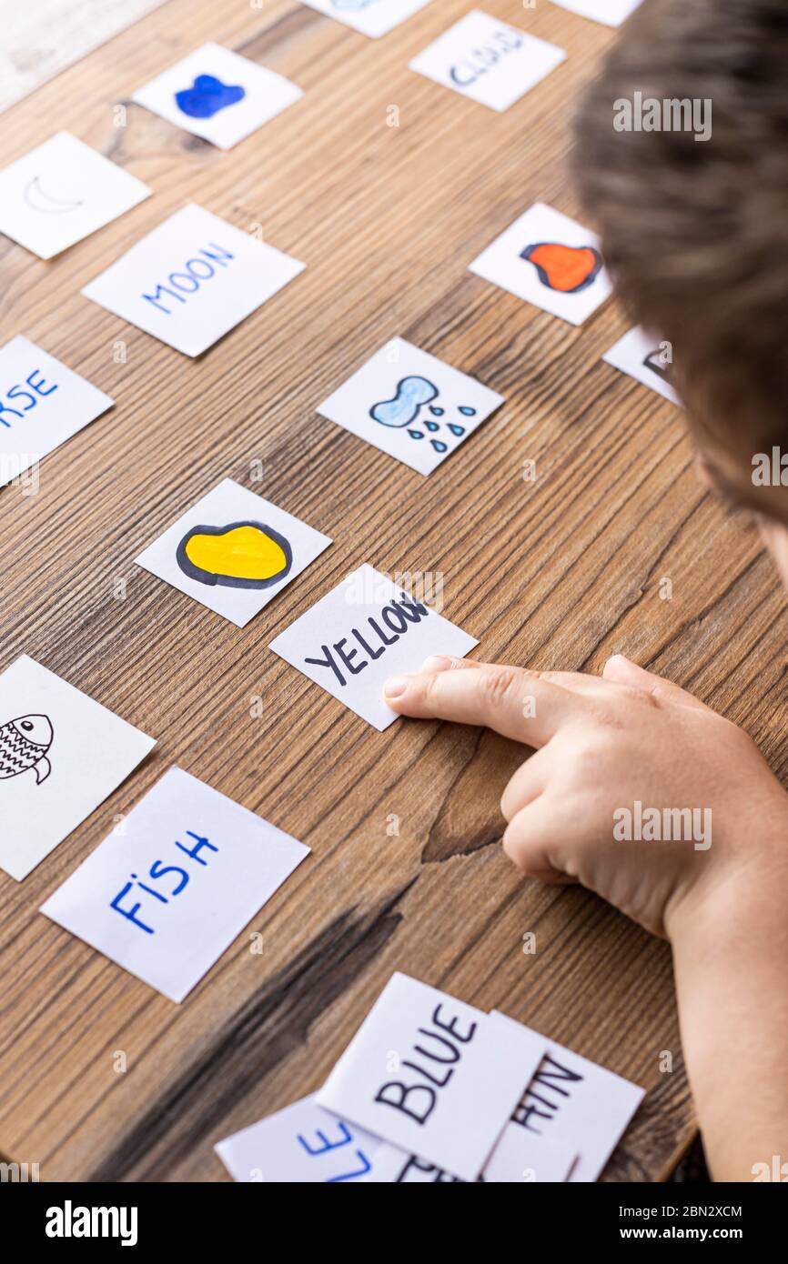 Little kid playing with cards of words and pictures. Time to learn ...