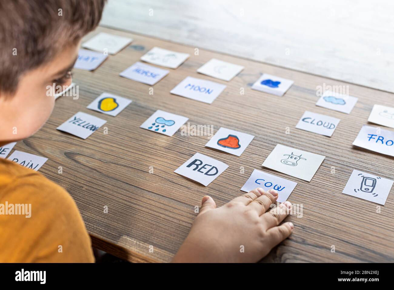 Little kid playing with cards of words and pictures. Time to learn ...