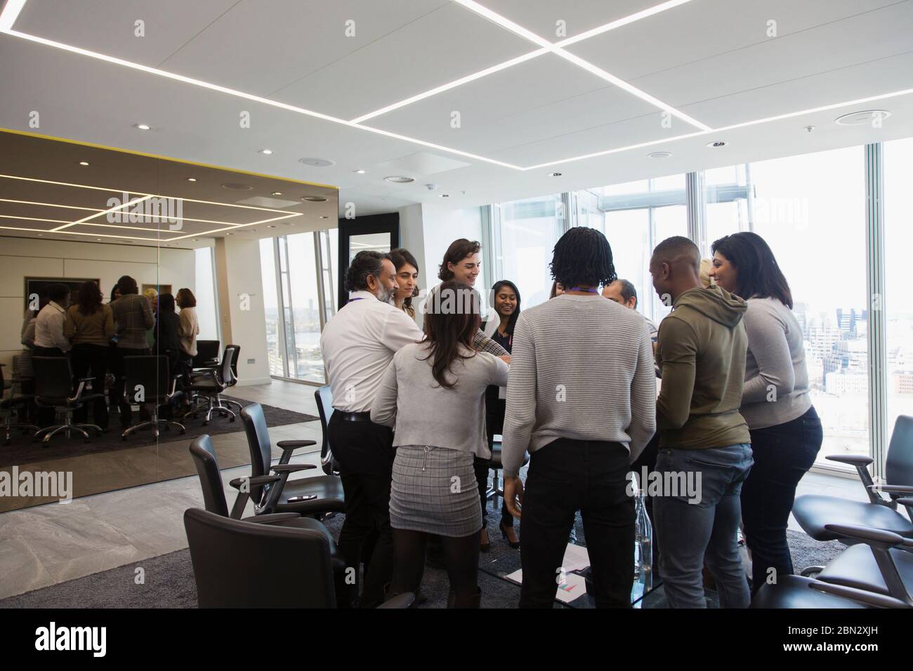 Business people standing in huddle in office Stock Photo - Alamy