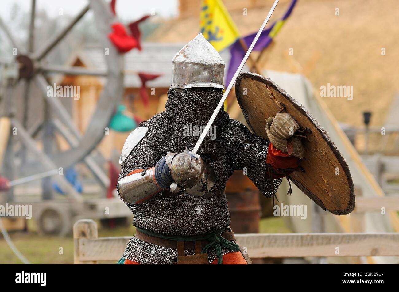 Reenactor dressed in armor of medieval knight reconstructing swords ...