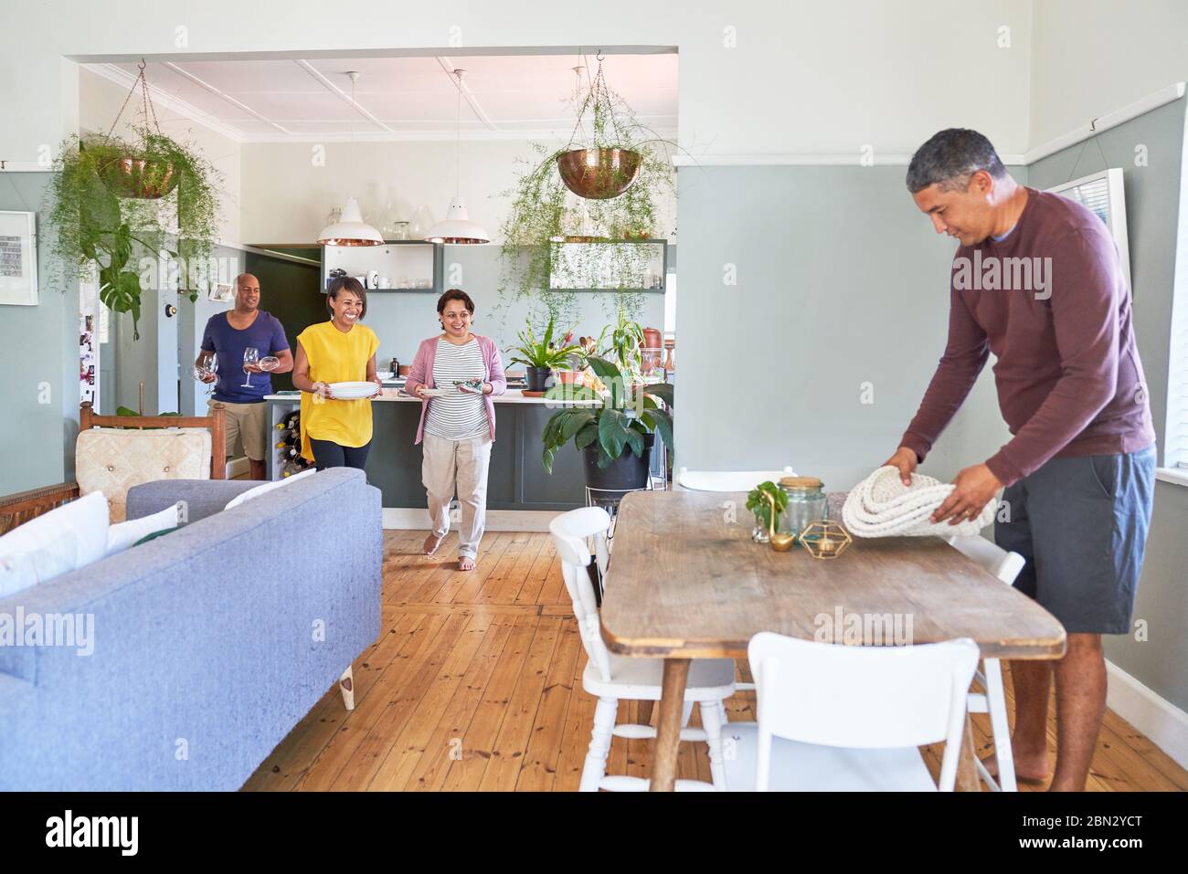 Mature couples setting dining table for lunch Stock Photo - Alamy