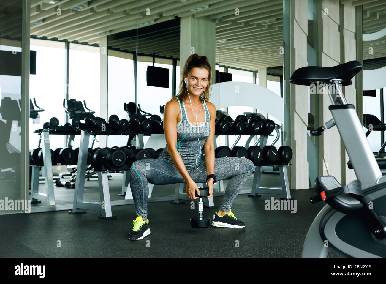Young and beautiful woman working out with dumbbells in gym Stock Photo ...