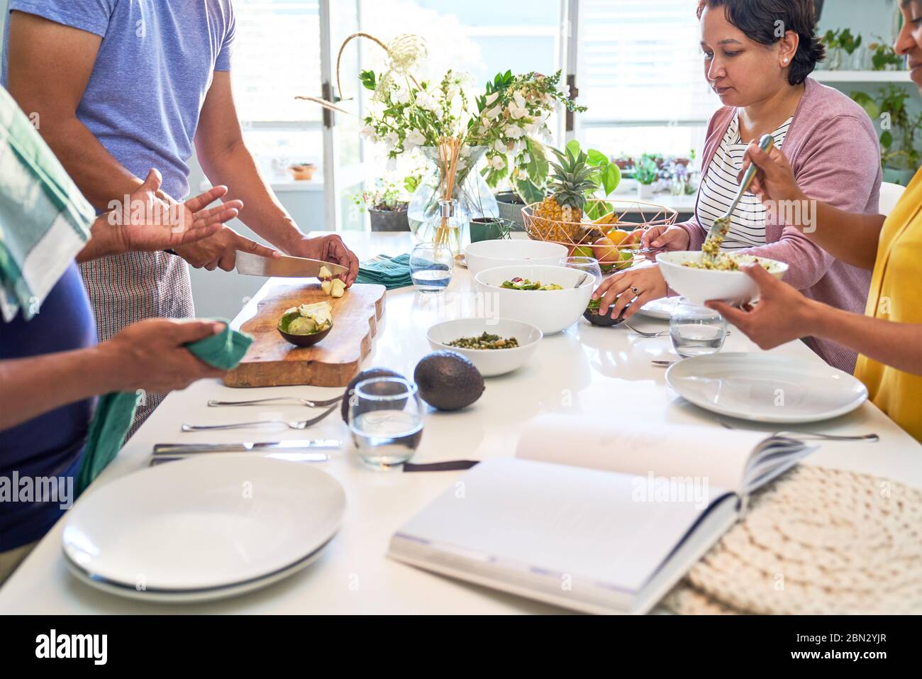 Couples cooking and eating at kitchen island Stock Photo - Alamy