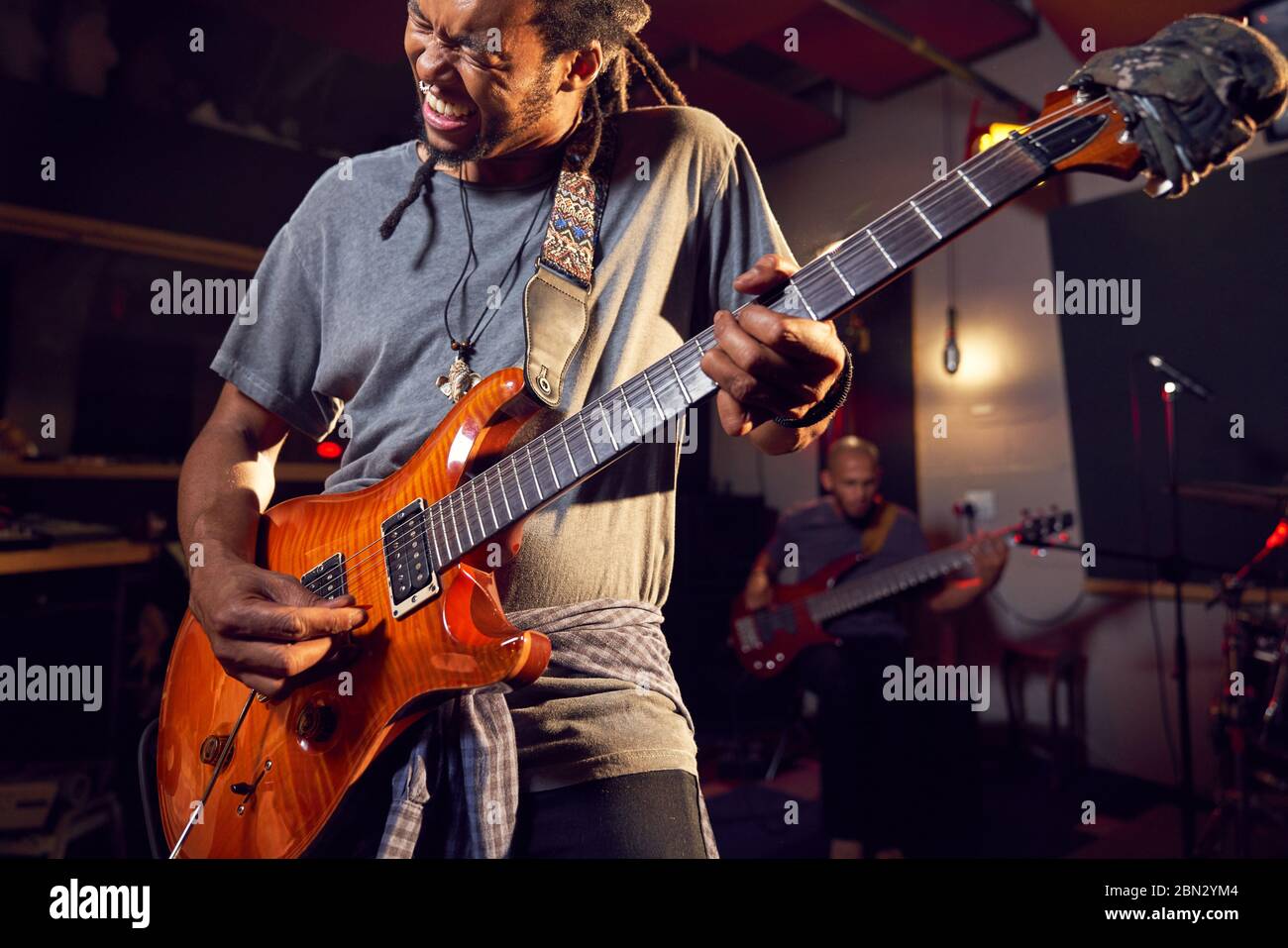 Male musician playing electric guitar in recording studio Stock Photo ...