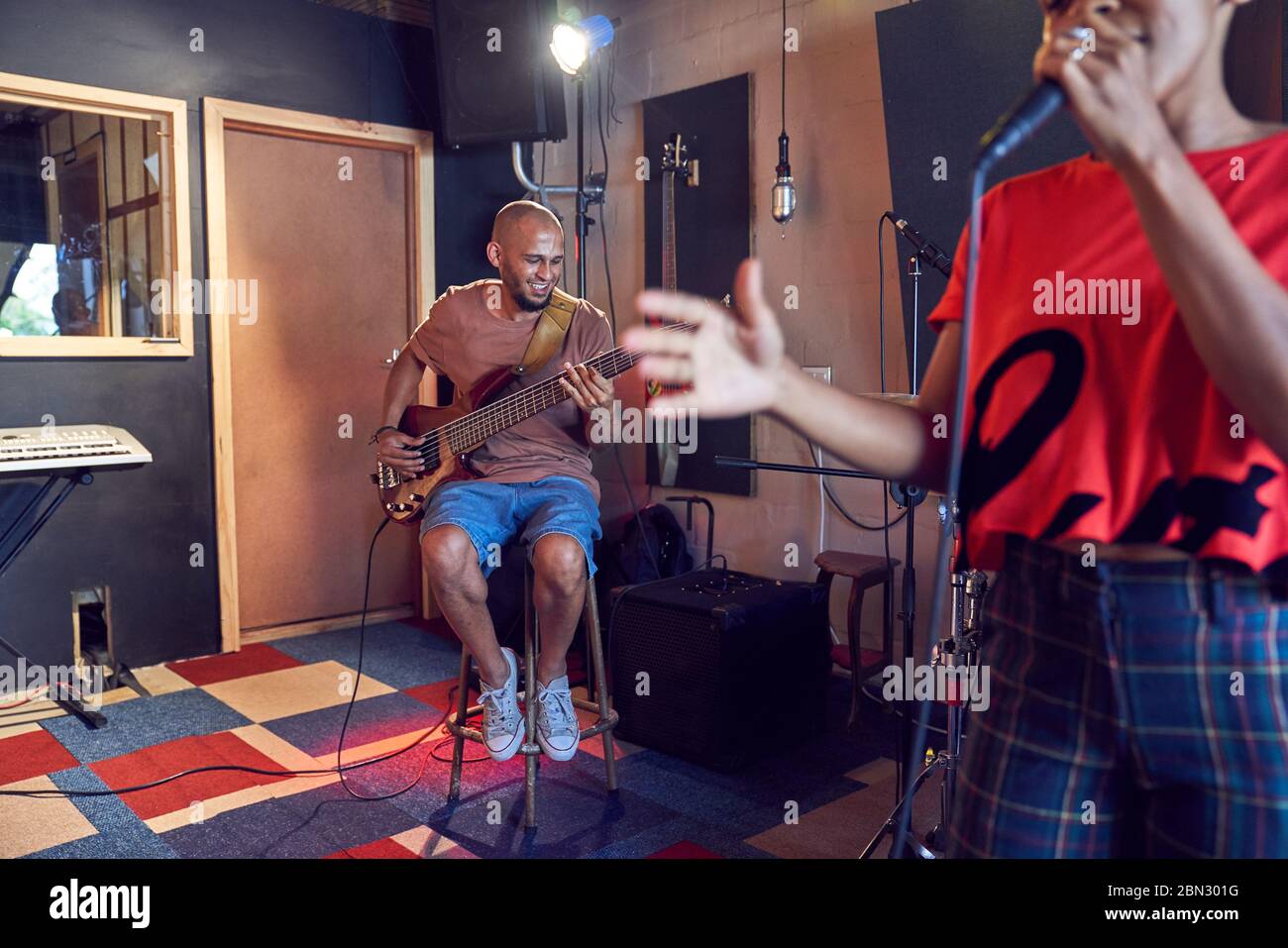 Musicians singing and playing guitar in recording studio Stock Photo ...