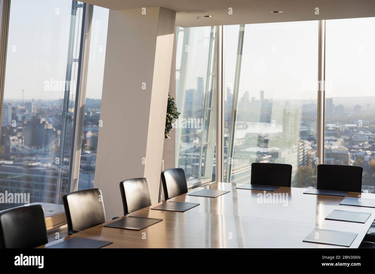 Modern conference room overlooking sunny city Stock Photo - Alamy