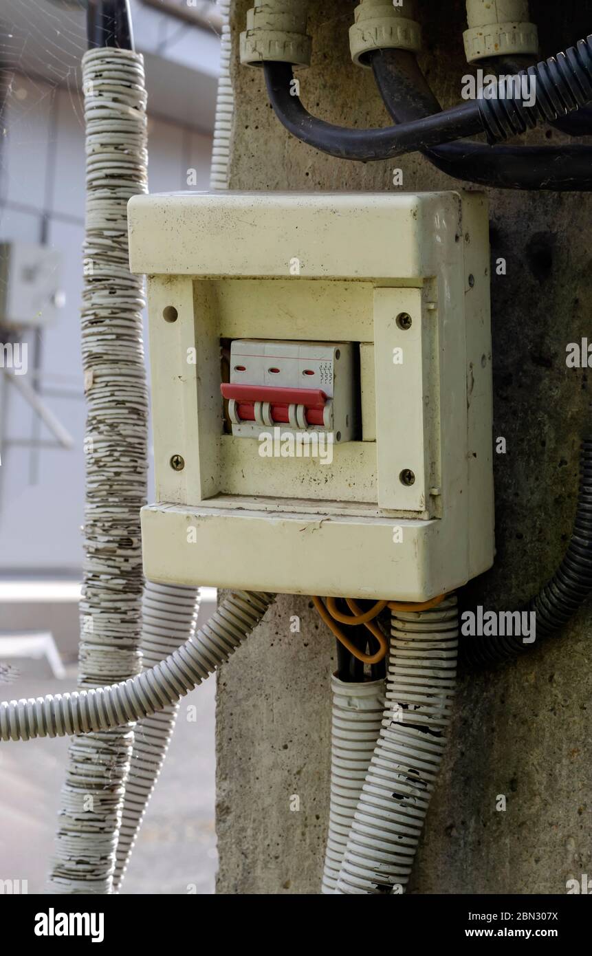 Old three-pole electric switch on a concrete pillar outdoors. Outdoor ...