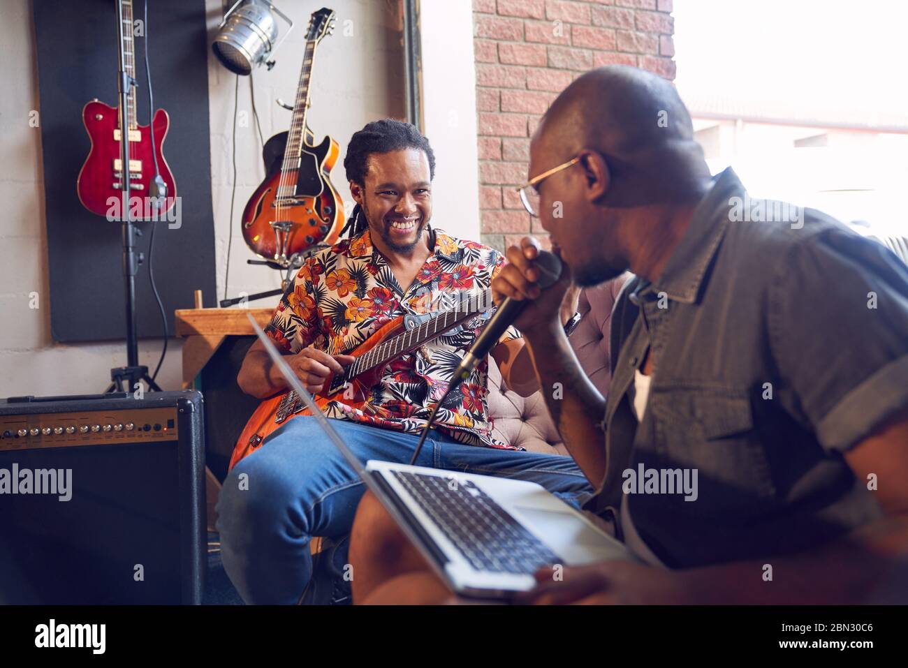 Happy male musicians practicing in recording studio Stock Photo - Alamy