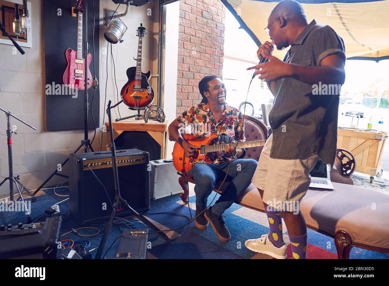 Happy male musicians practicing in garage recording studio Stock Photo ...