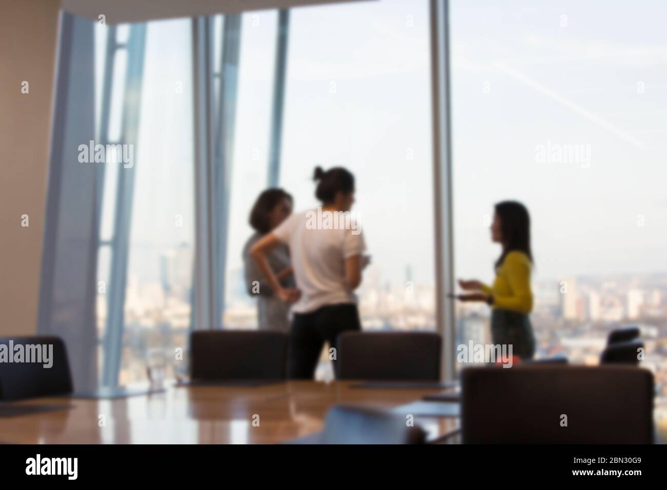 Business people talking at highrise conference room window Stock Photo ...