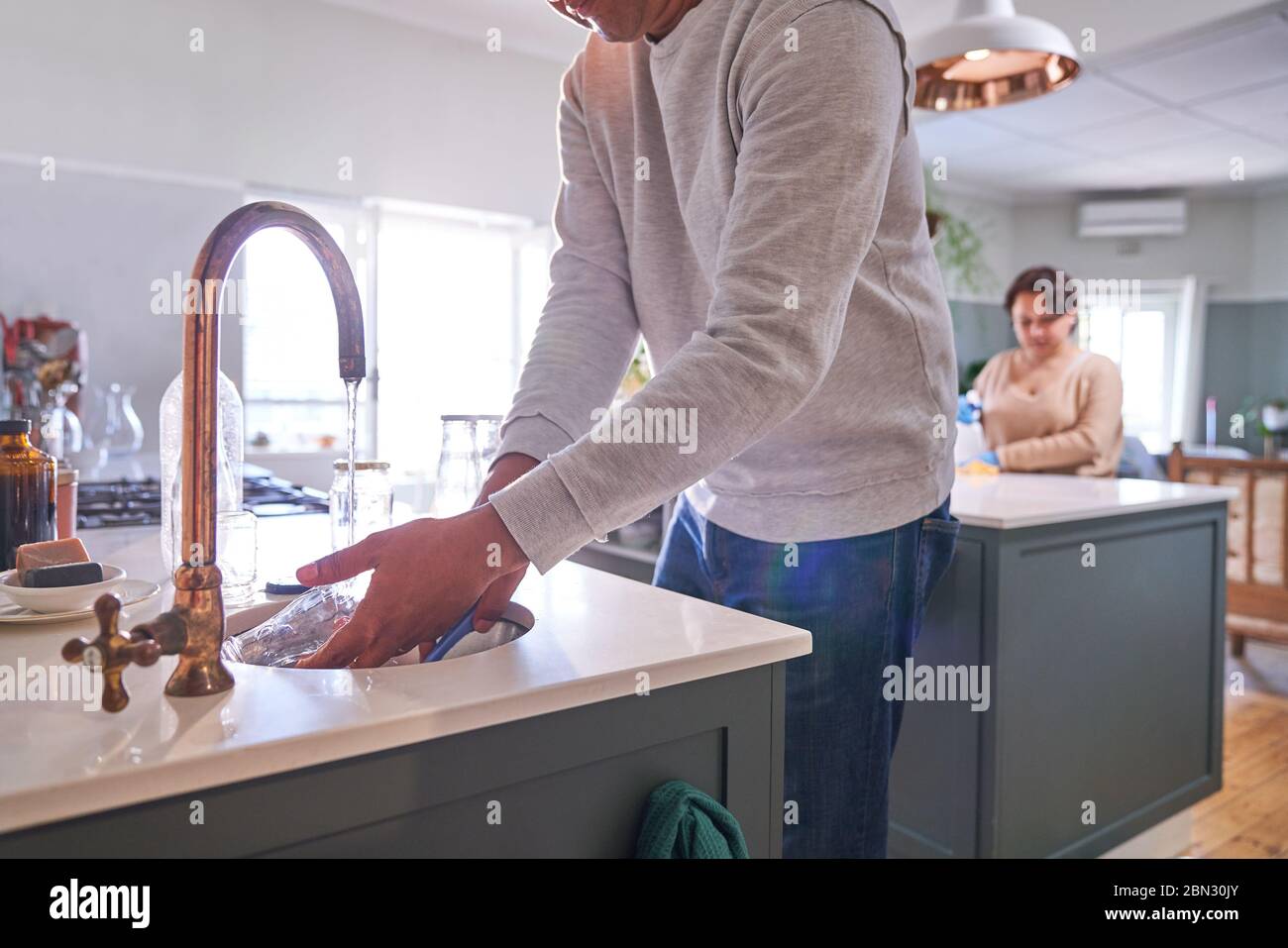 Man doing dishes at kitchen sink Stock Photo - Alamy