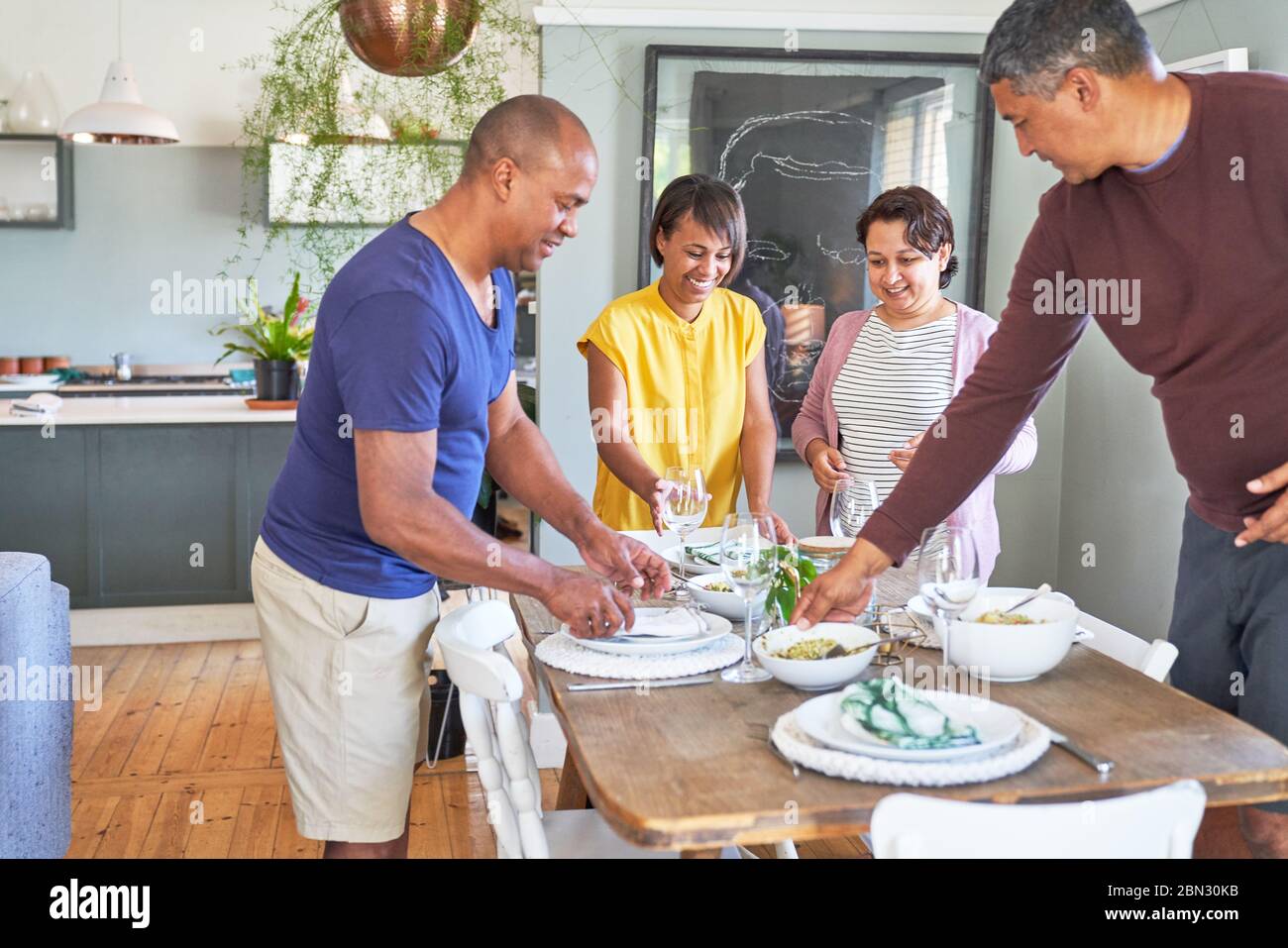 Mature couple friends setting the table for lunch Stock Photo - Alamy