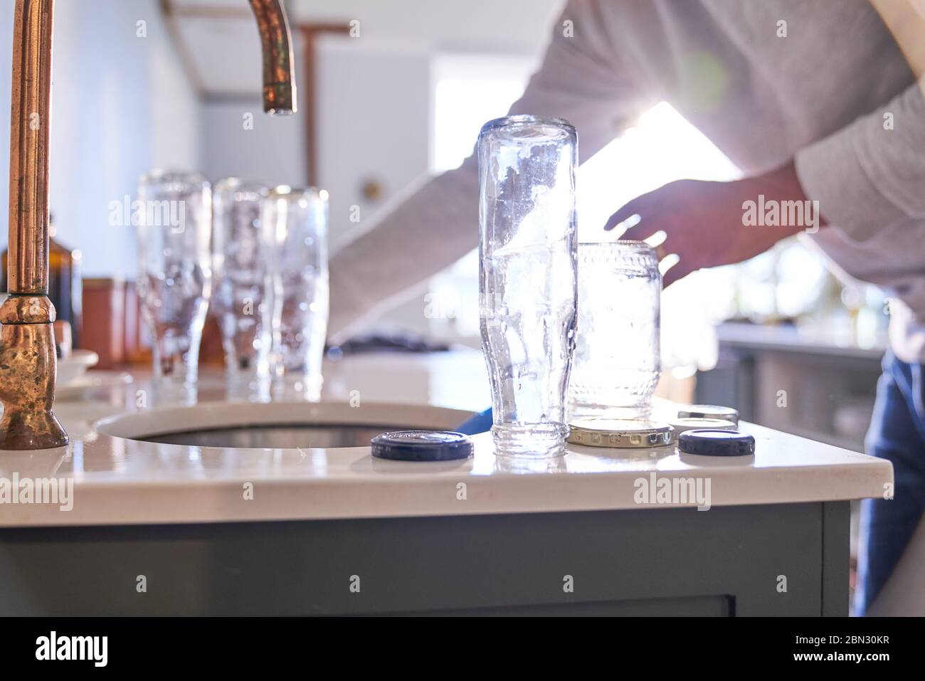 Man washing glass bottles at kitchen sink Stock Photo - Alamy