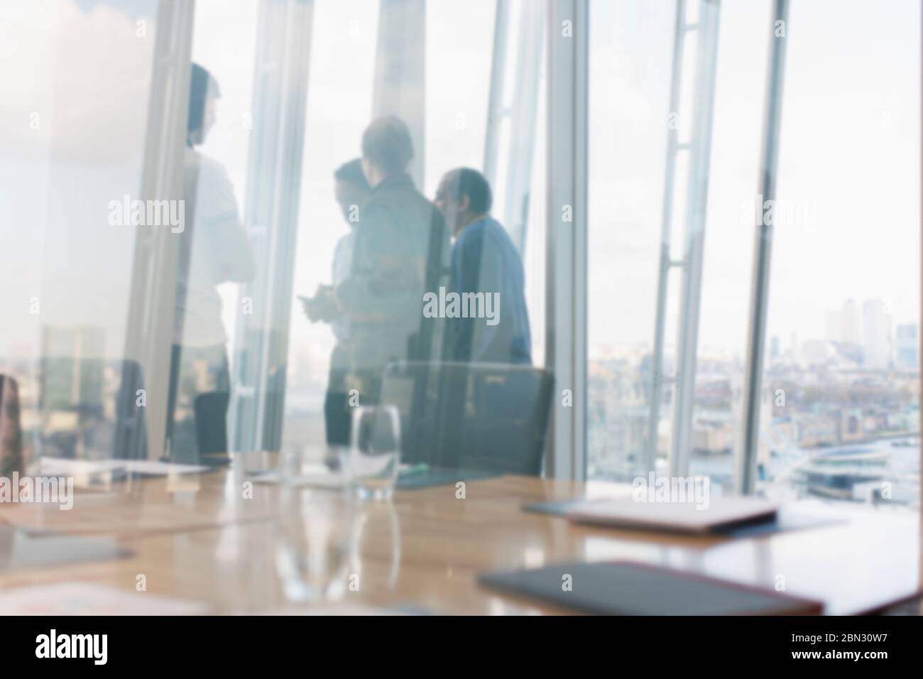 Business people talking at urban highrise office window Stock Photo - Alamy