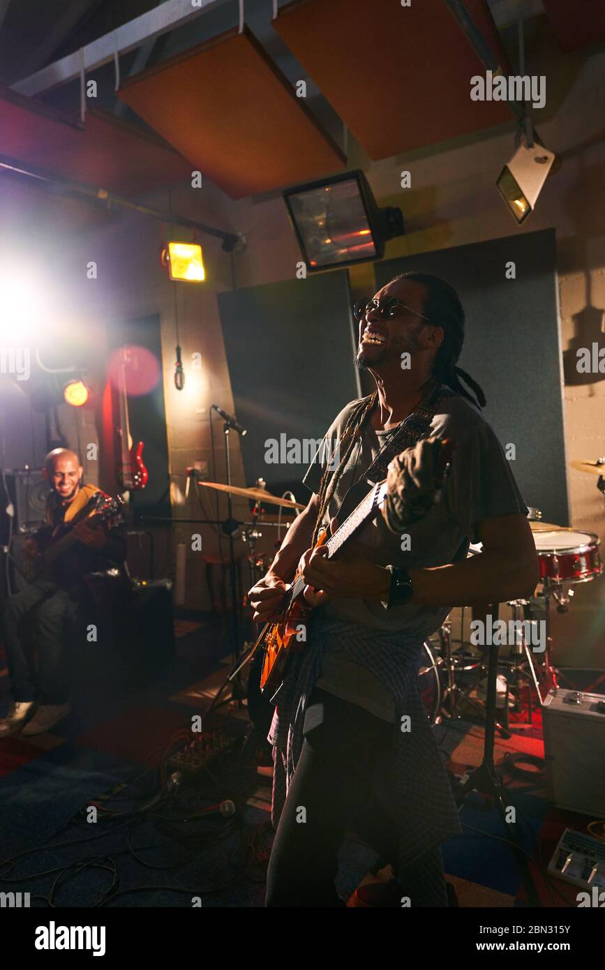Male musician playing guitar in recording studio Stock Photo - Alamy