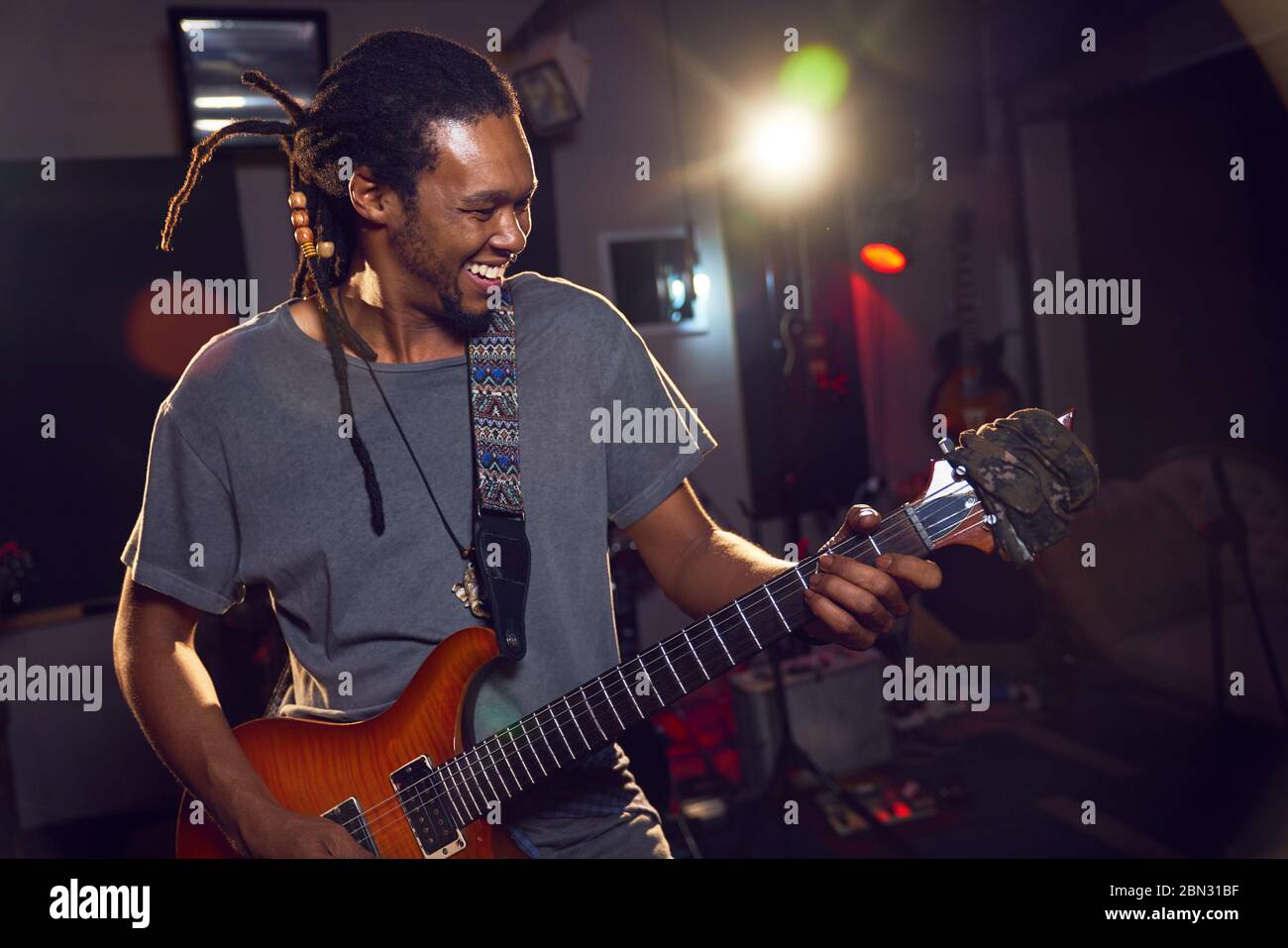 Happy male musician playing electric guitar in recording studio Stock ... Happy male musician playing electric guitar in recording studio Stock ...