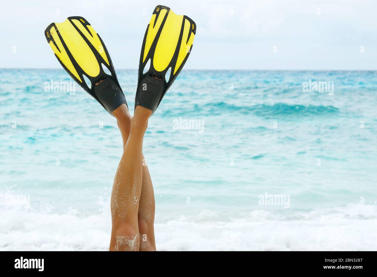 Female legs in flippers on the beach Stock Photo - Alamy