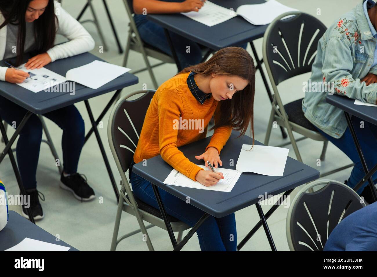 Focused high school girl student taking exam at desk in classroom Stock ...