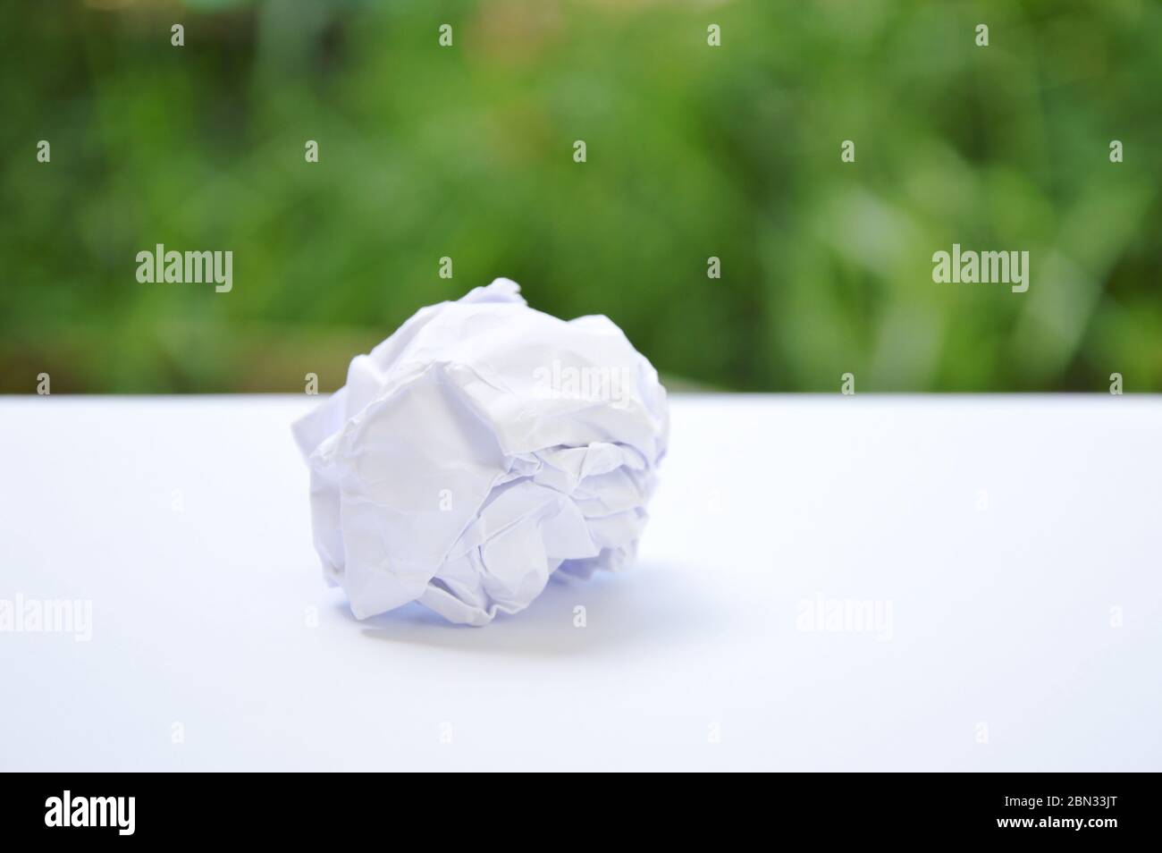 Crumpled white paper roll in garden background Stock Photo - Alamy