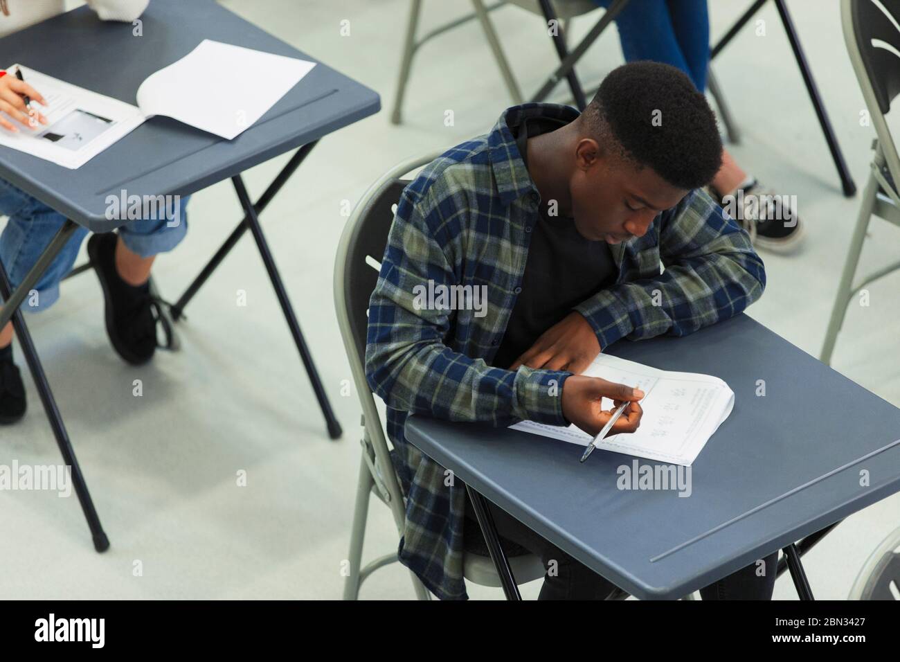 Focused high school boy student taking exam at desk in classroom Stock ...