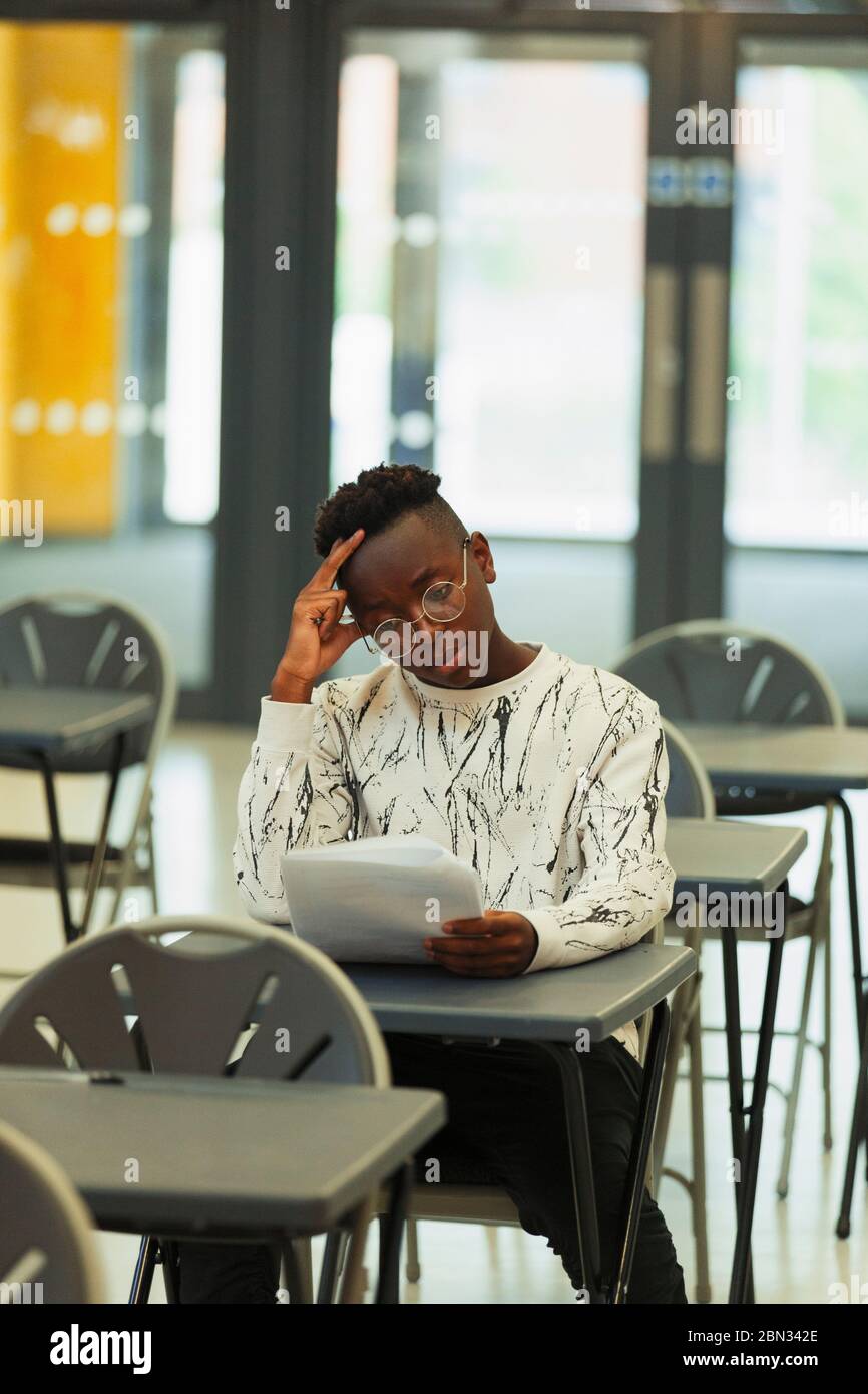Focused high school boy student taking exam at desk in classroom Stock ...