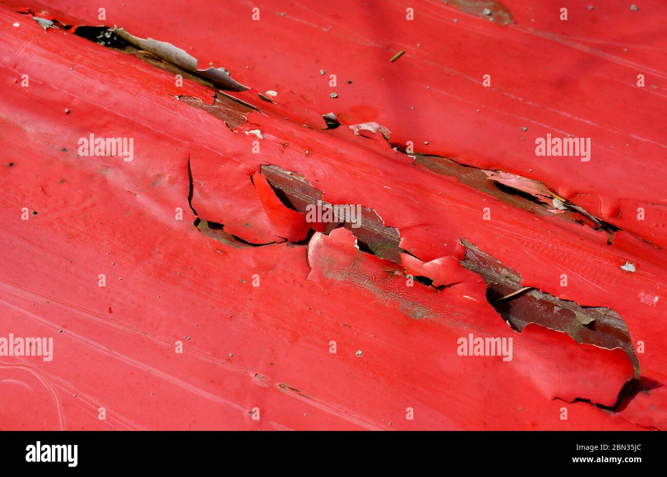 Peeling red paint on fiberglass canoe bottom Stock Photo - Alamy