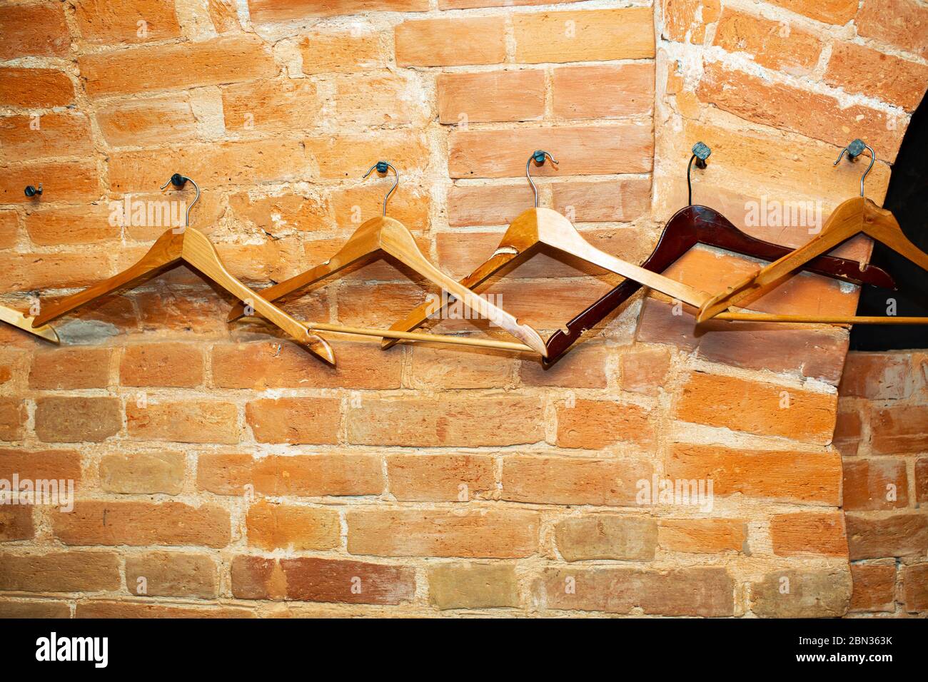 Pub room decor, wooden clothes hangers hanging on a red brick arched ...