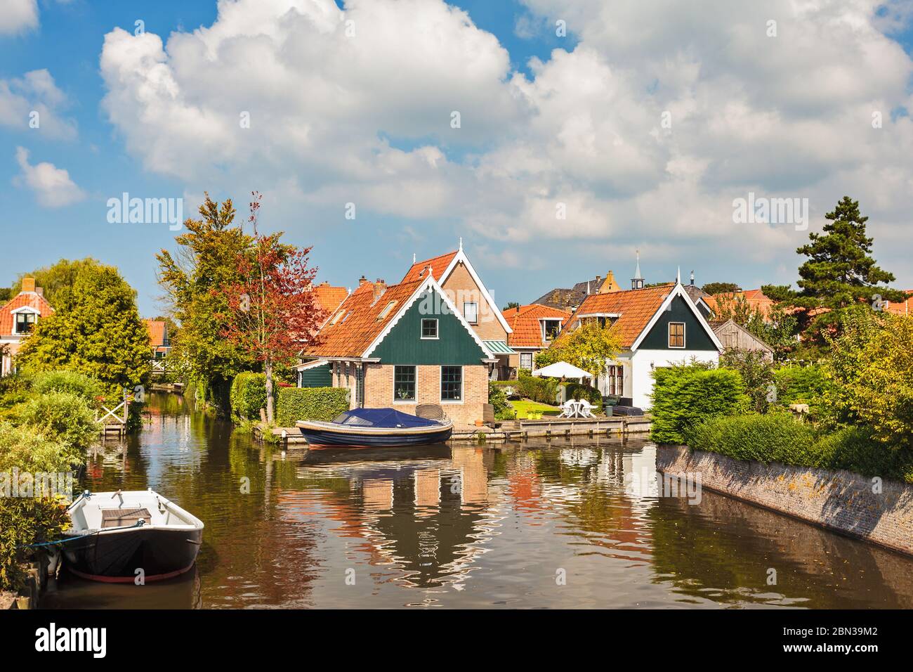 Canal with houses in the small Dutch village of Hindeloopen in ...