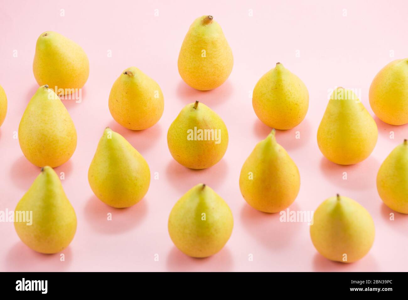 Yellow lots of pears on a pink background Stock Photo - Alamy