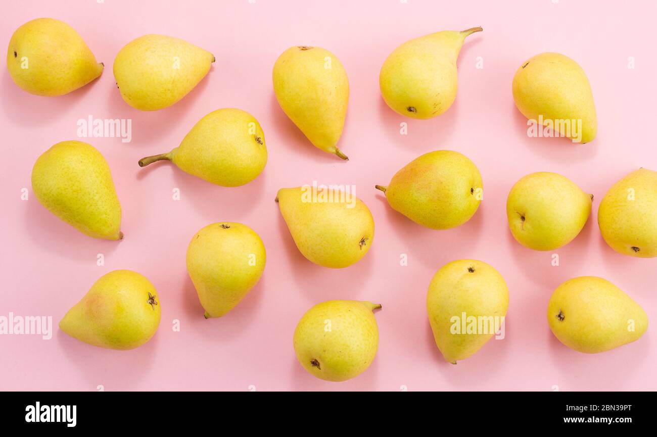 Yellow lots of pears on a pink background Stock Photo - Alamy