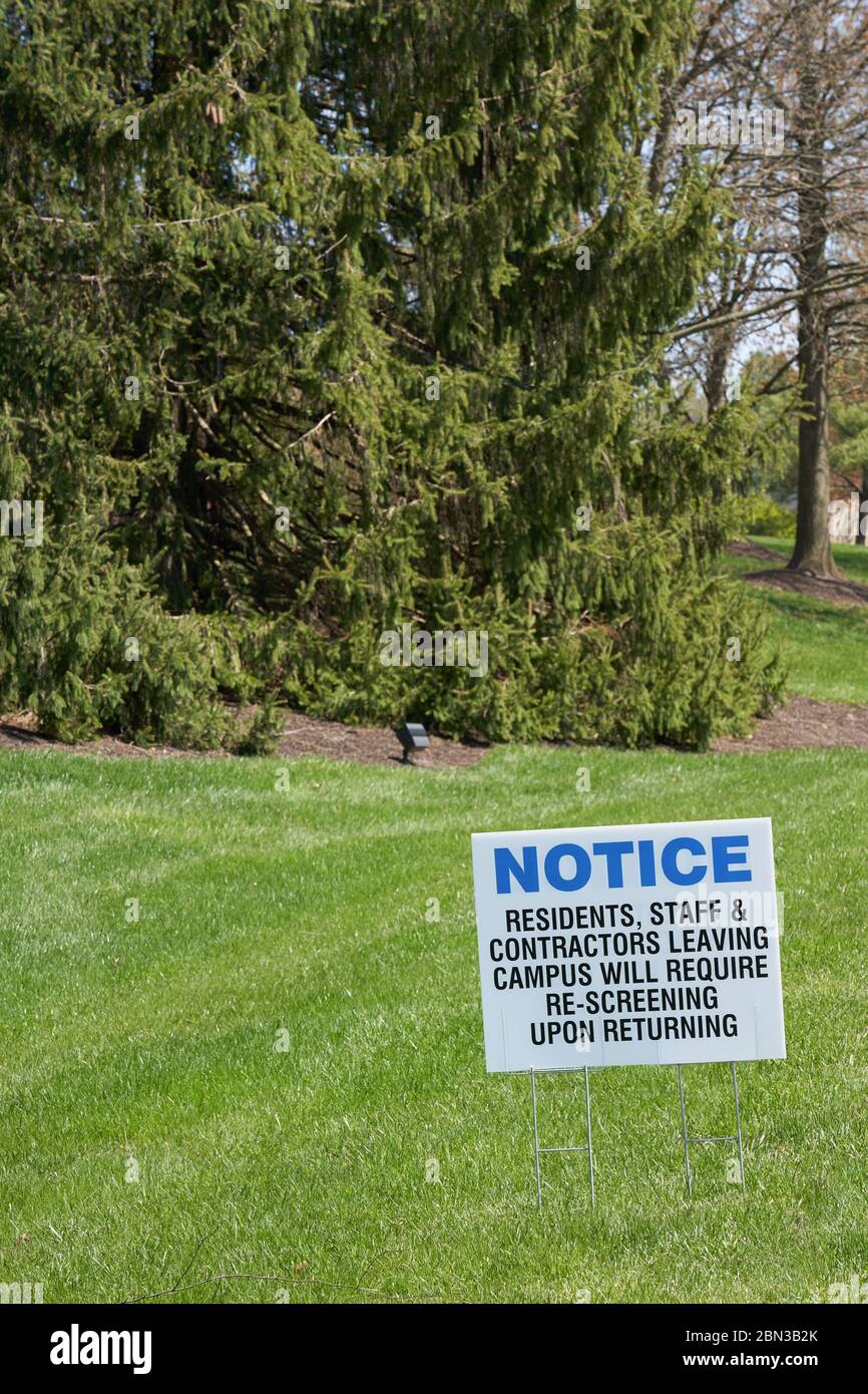 sign on a green lawn with tree behind giving notice that residents ...