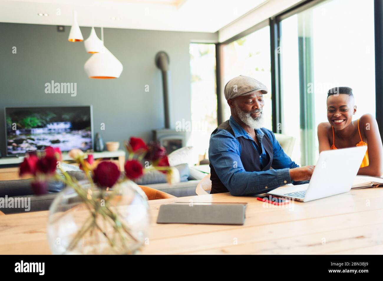 Father and daughter using laptop at dining table Stock Photo - Alamy