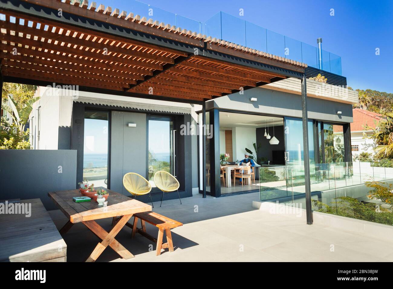 Sunny, modern home showcase patio Stock Photo - Alamy