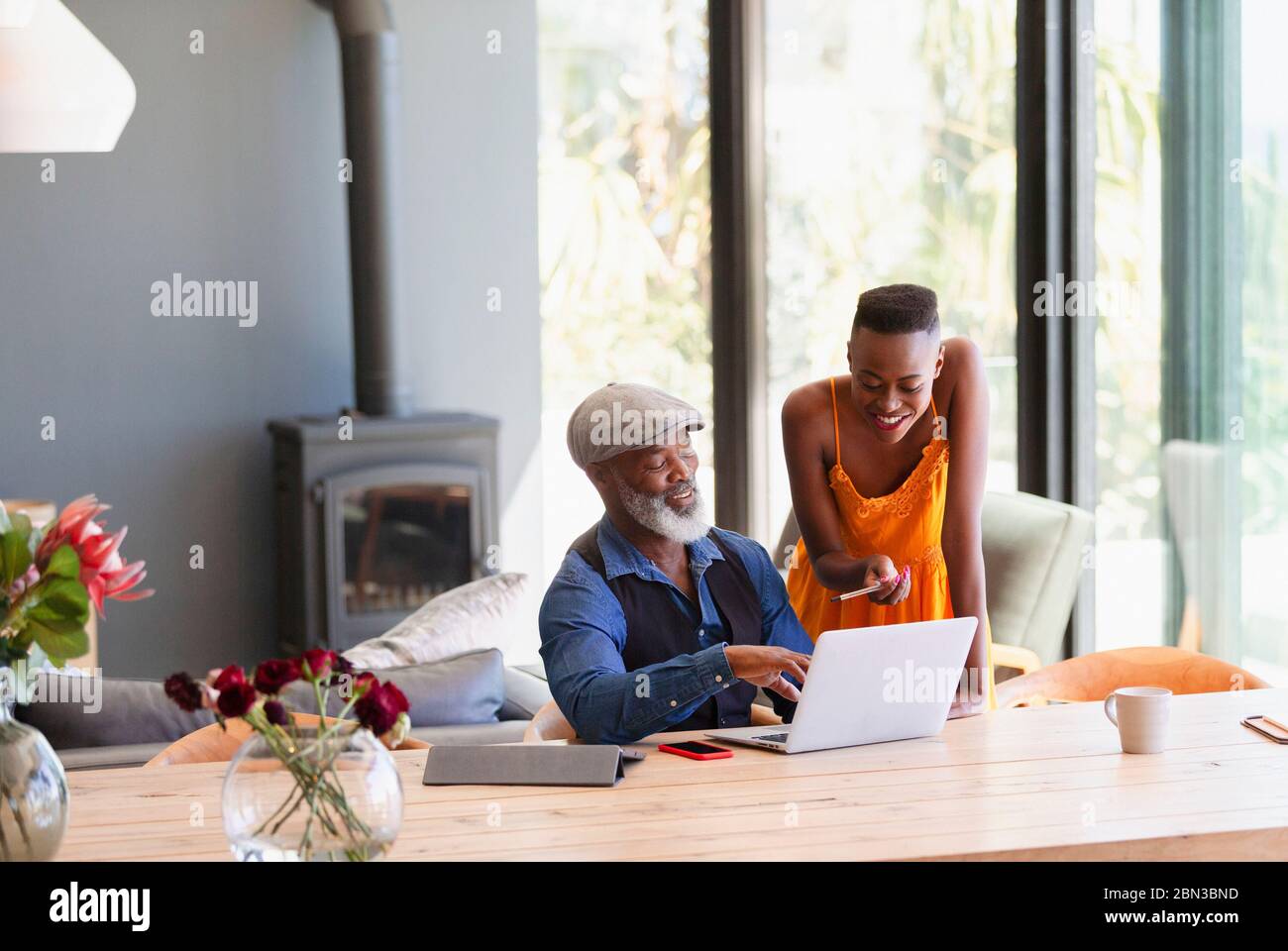 Father and daughter using laptop at dining table Stock Photo - Alamy
